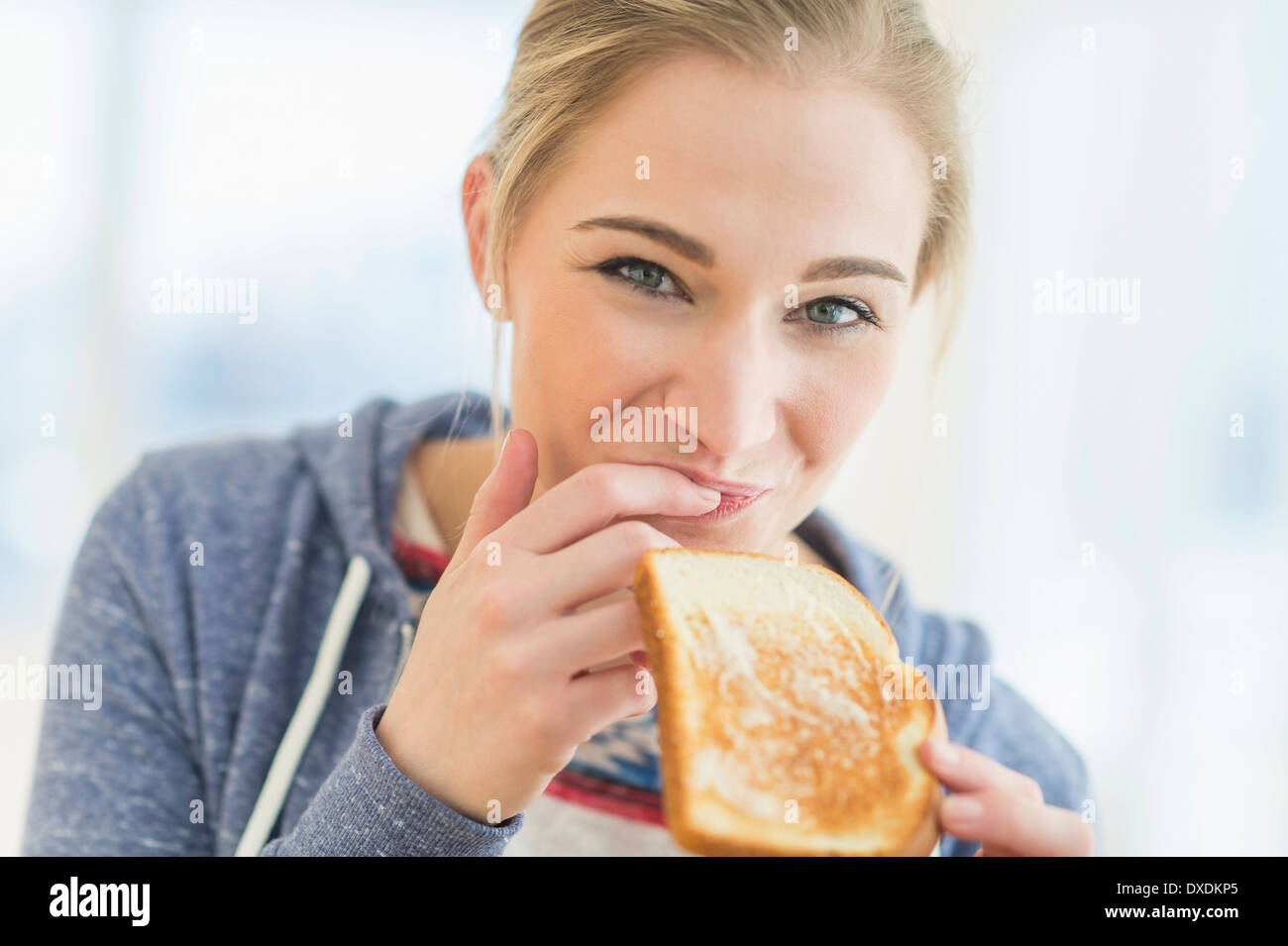 Woman eating toast Stock Photo - Alamy