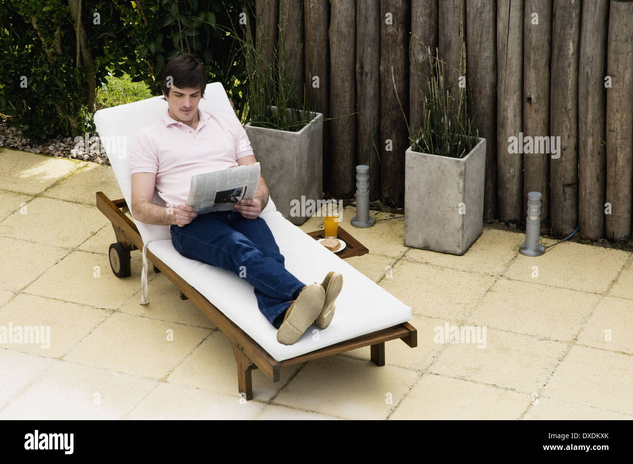 Young man reading by the swimming pool Stock Photo - Alamy