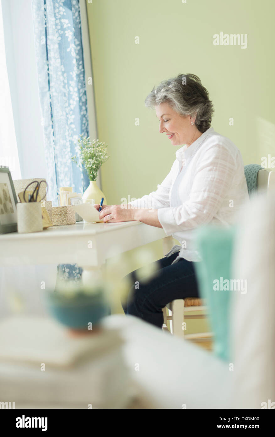 Mature woman writing letter Stock Photo - Alamy