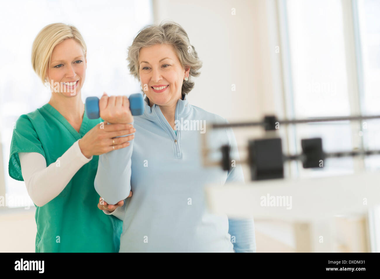 Mature woman exercising with personal trainer Stock Photo - Alamy