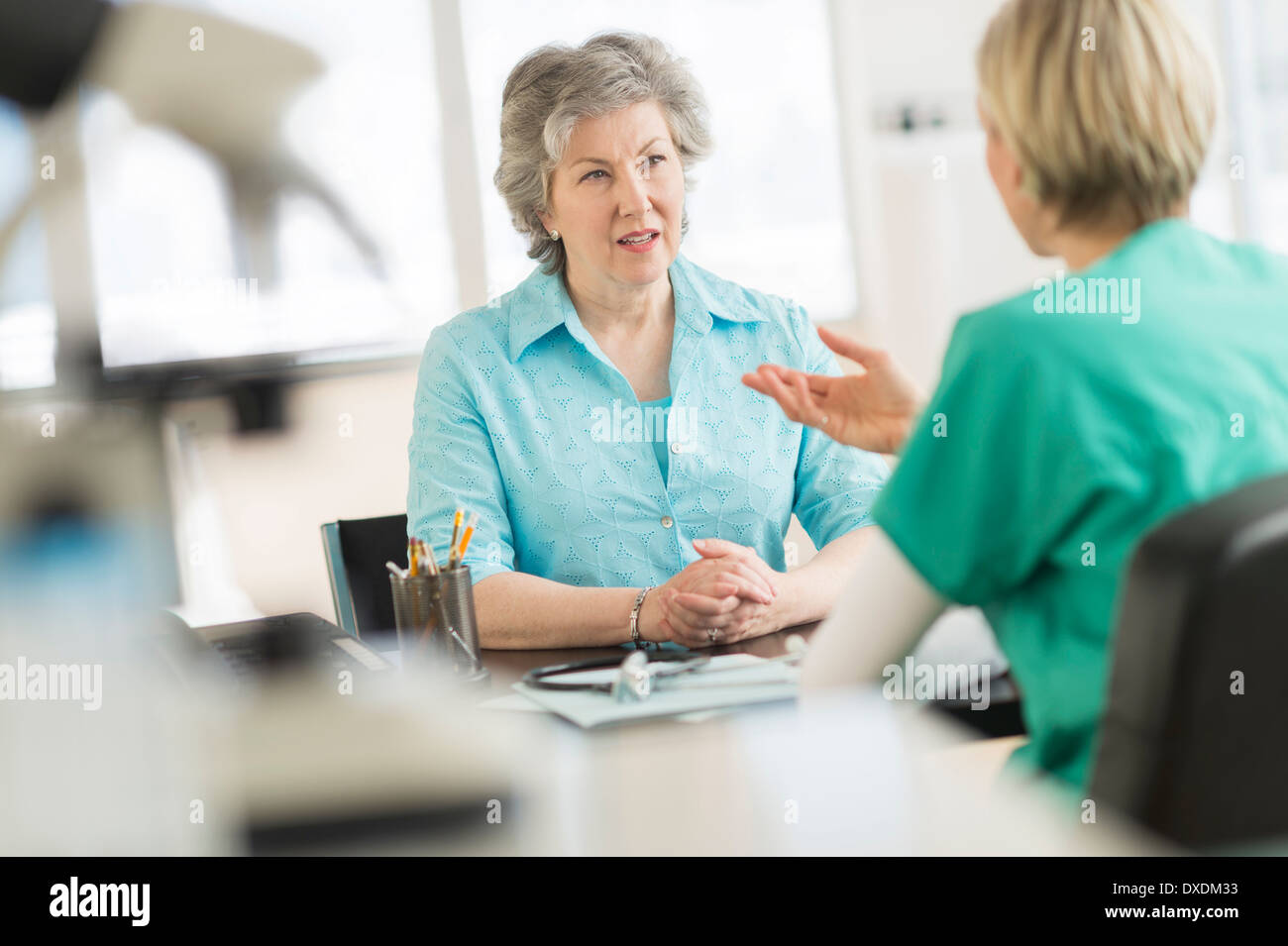 Doctor talking to patient in doctor's office Stock Photo - Alamy