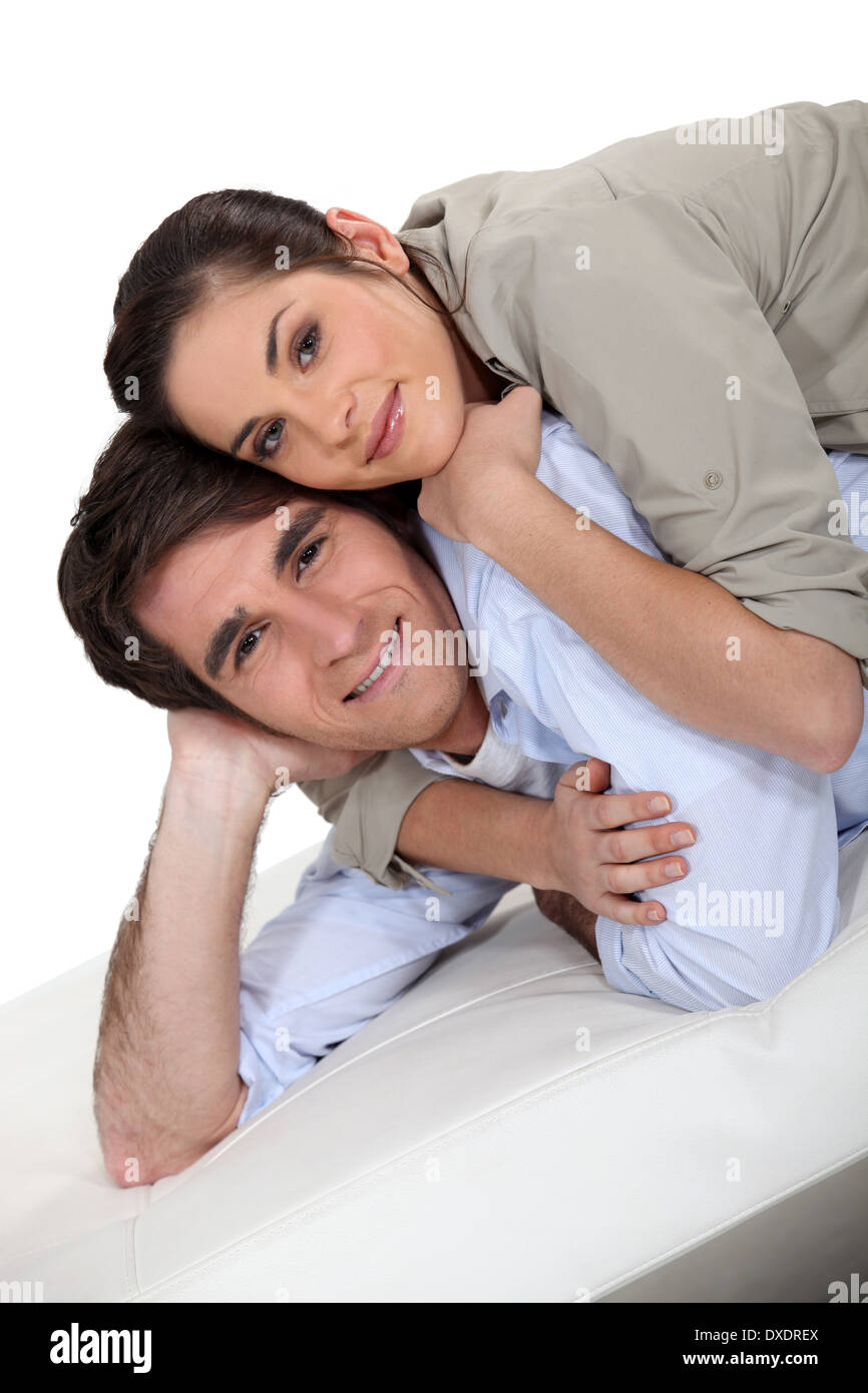 Portrait of a happy couple lying on a futon Stock Photo - Alamy