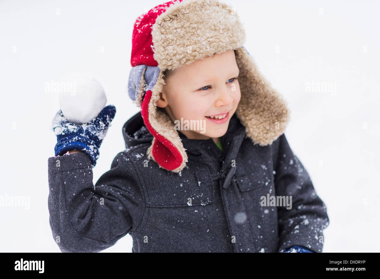 Boy (6-7) playing with snowball Stock Photo - Alamy