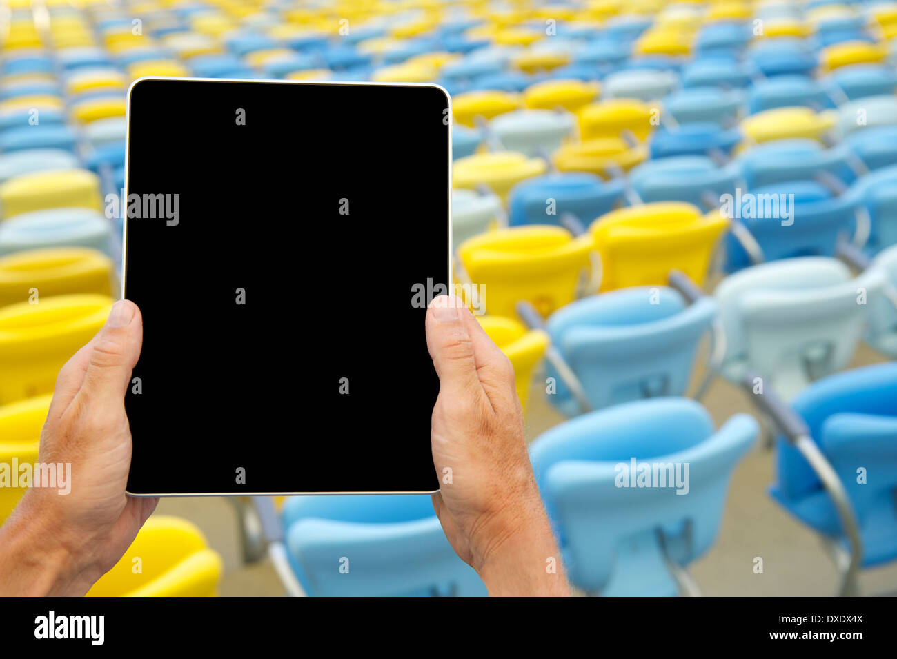 Hands holding blank tablet computer in football stadium Rio de Janeiro ...