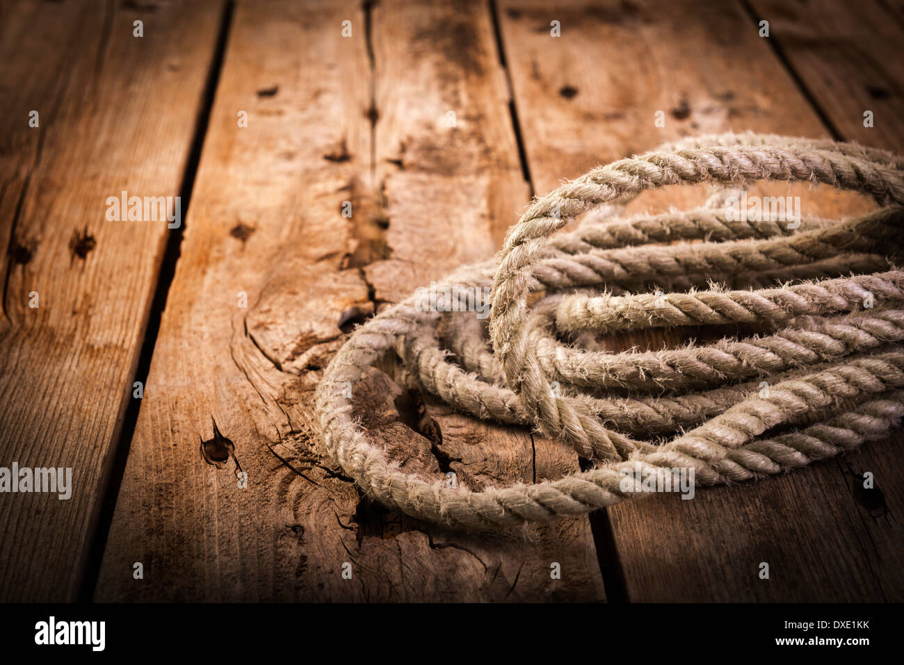 Old rope twisted and tied in a bundle on a rough wooden background ...