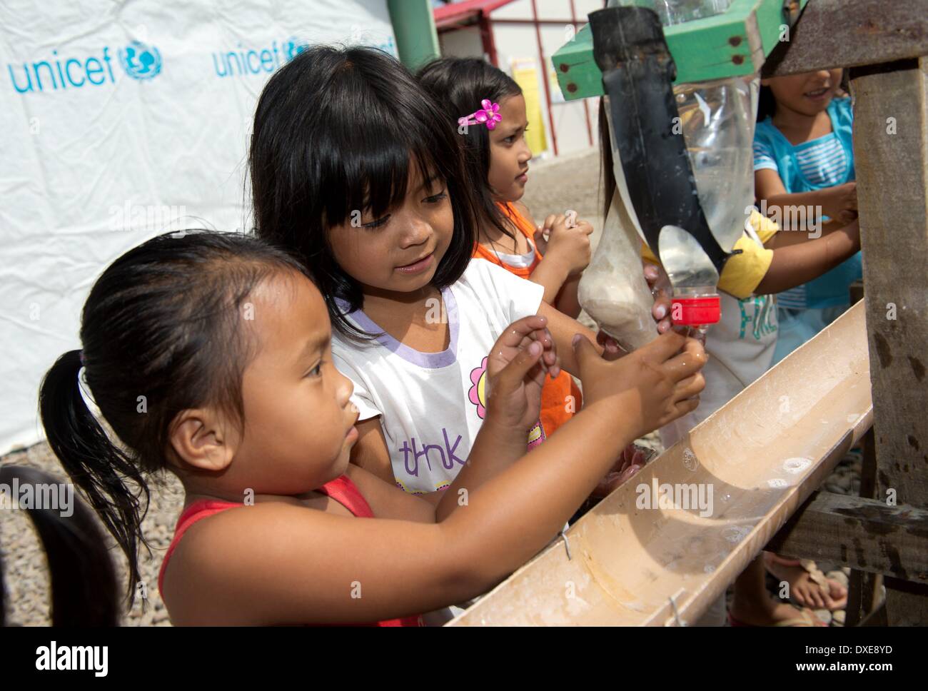 Schoolkids are washing their hands at a device that was built with the ...