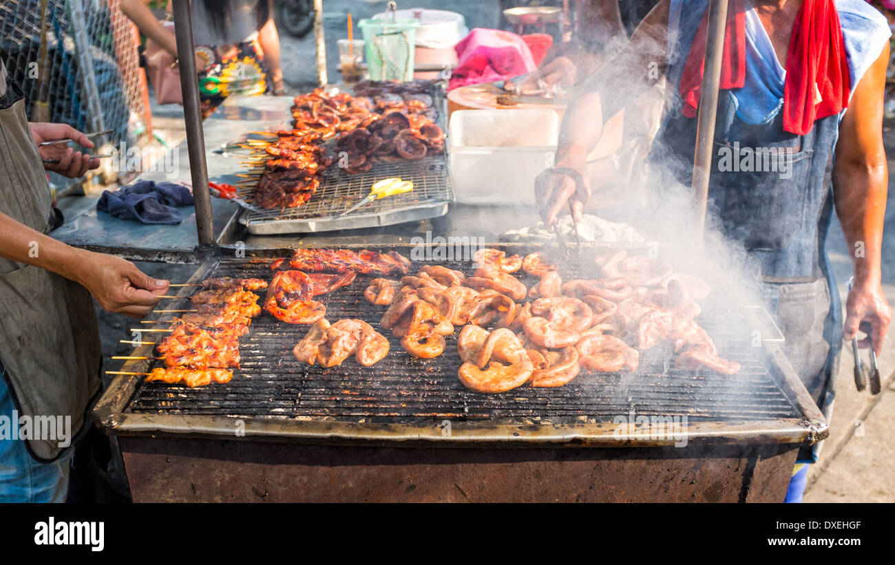 man cooking chitterlings and pork grill street food in thailand Stock ...