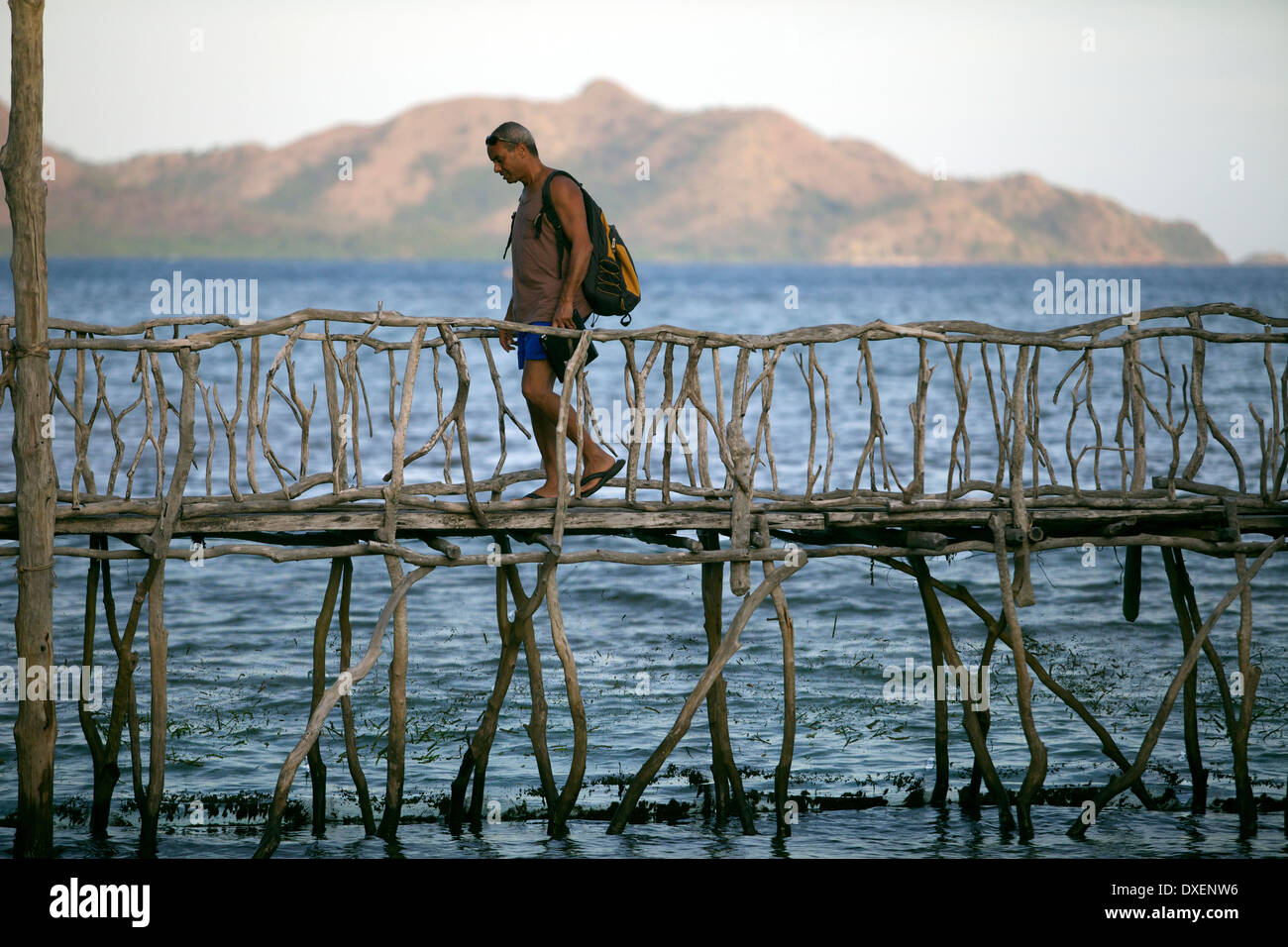 Man walking over a handmade bridge Stock Photo - Alamy