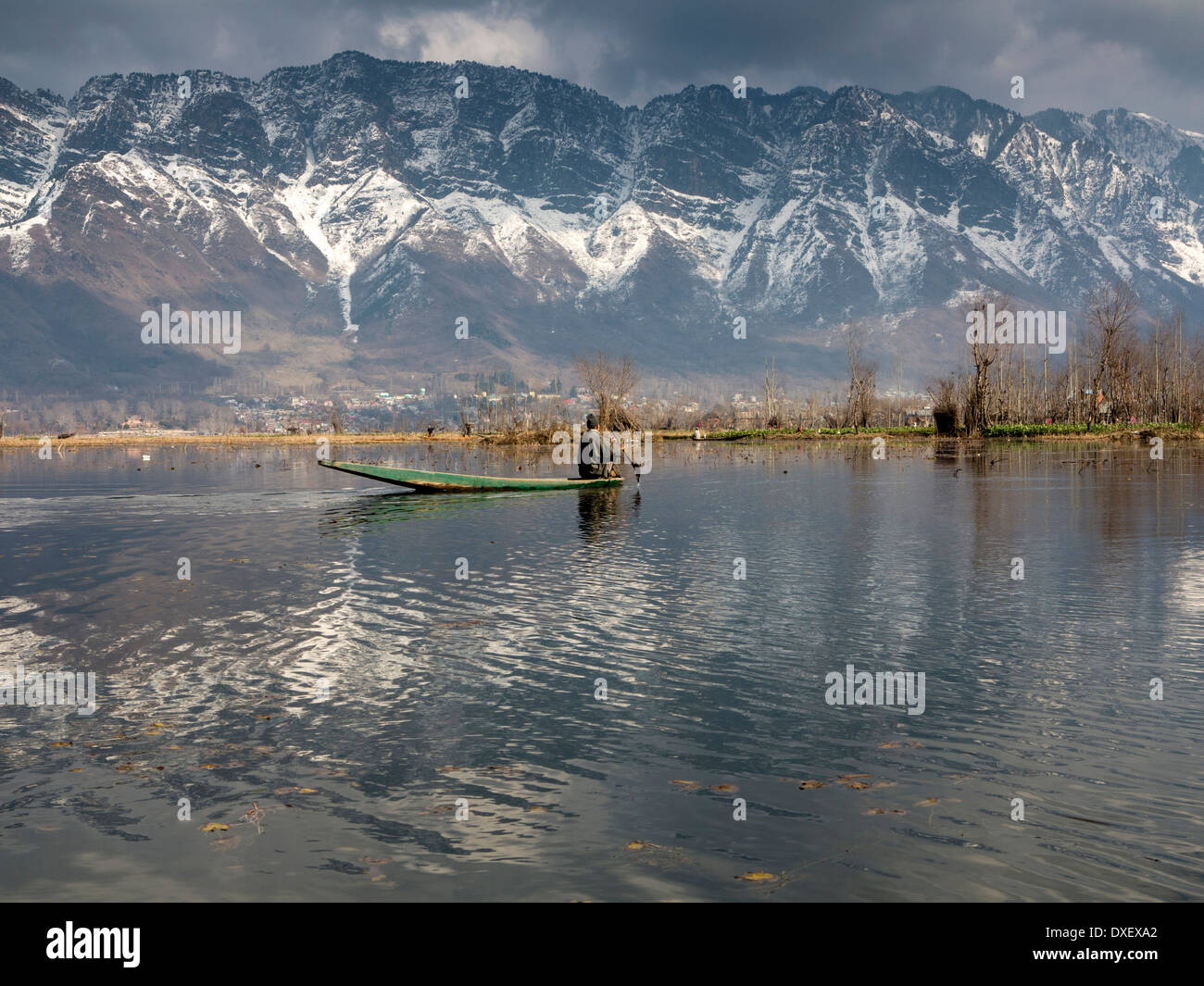 India, Kashmir, Srinagar, Nishar Suth, man in shikara below snow capped ...
