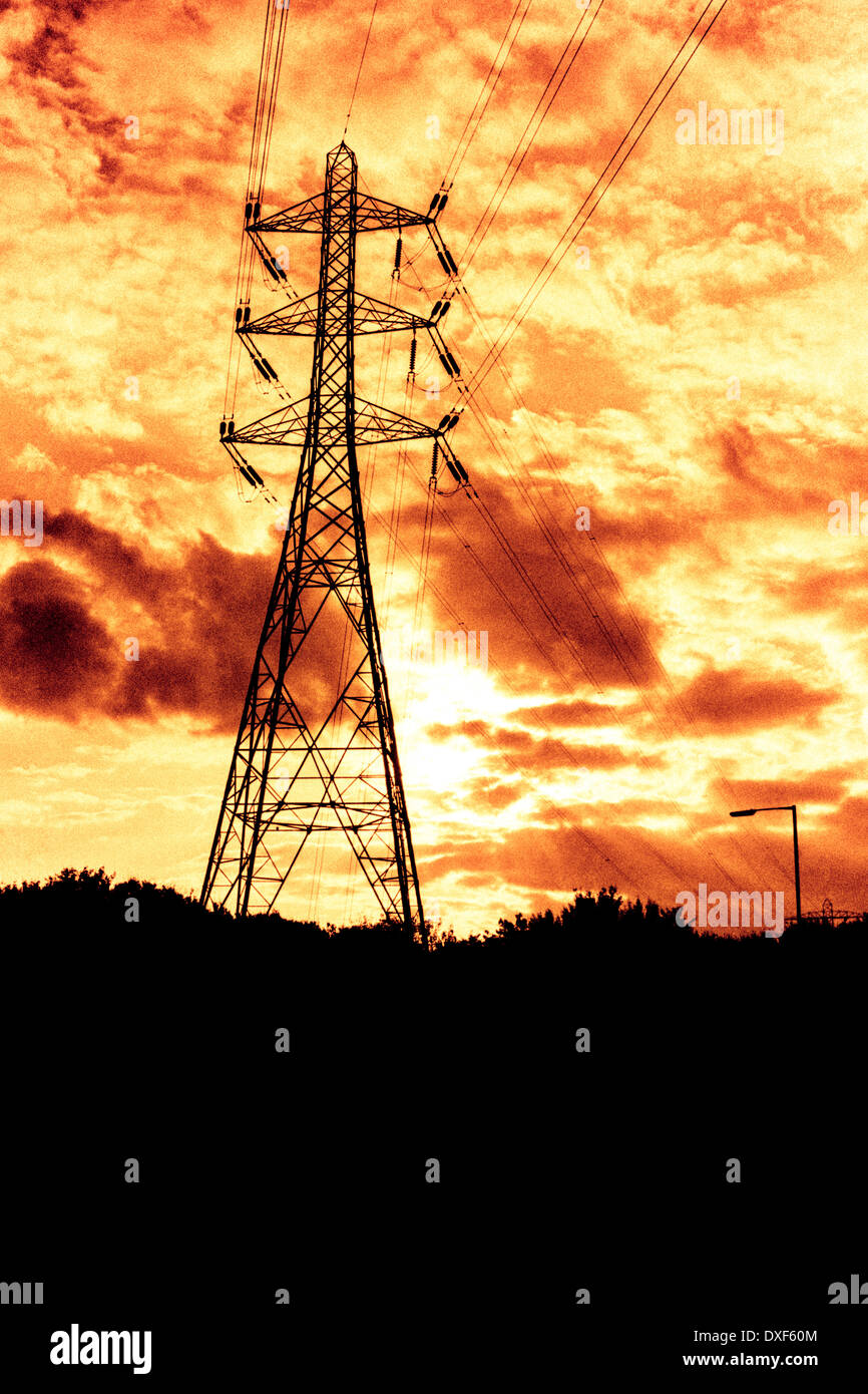 Electrical transmission tower over dramatic sunset sky. Toned grainy ...