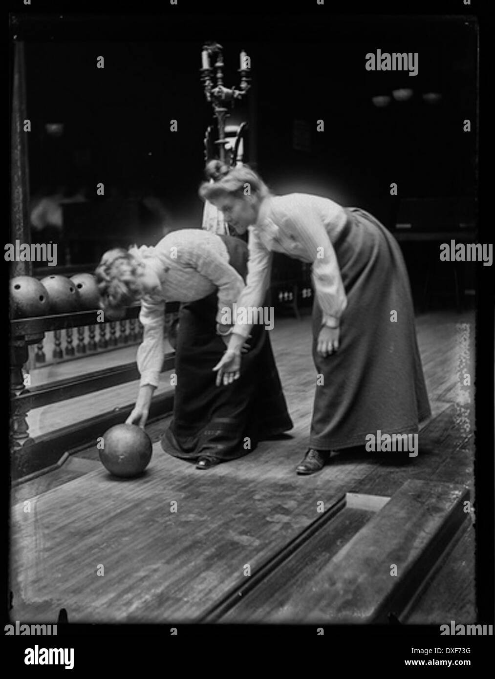 A vintage photograph of two women bowling, captured during a time when ...
