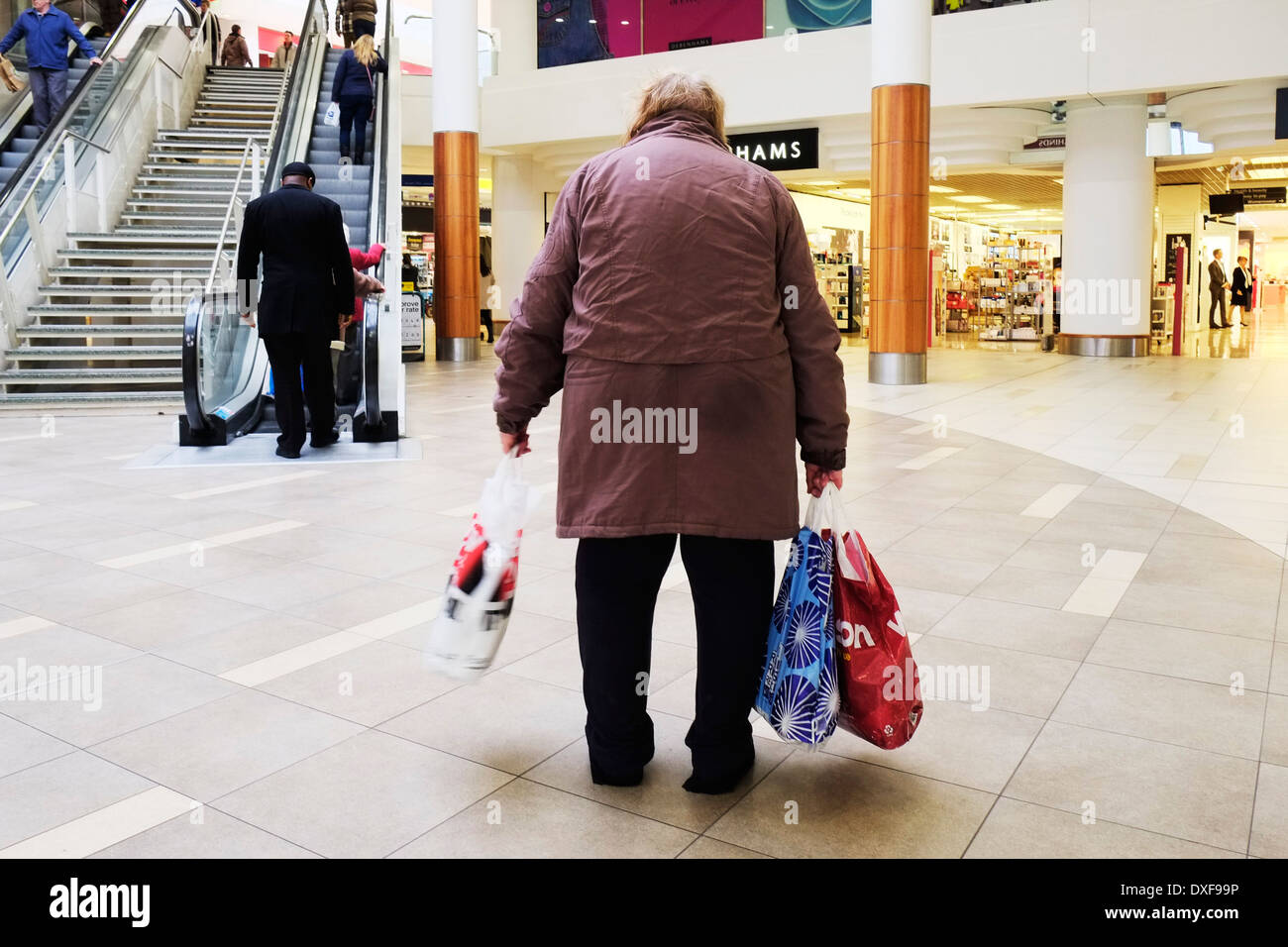 Rear view of a tired elderly shopper in a shopping mall Stock Photo - Alamy