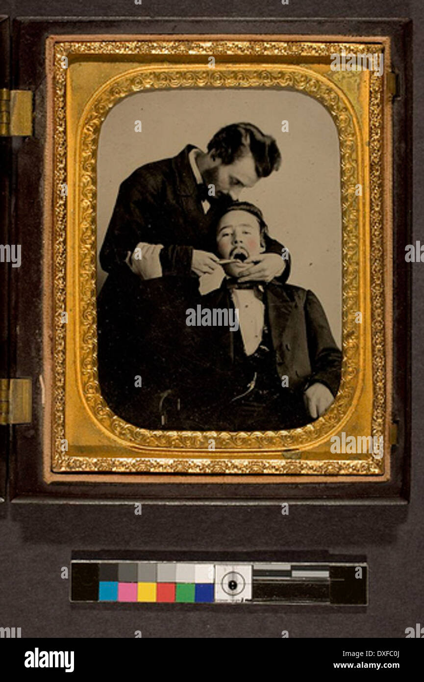 A vintage photograph captures a dentist and patient, depicting a moment ...