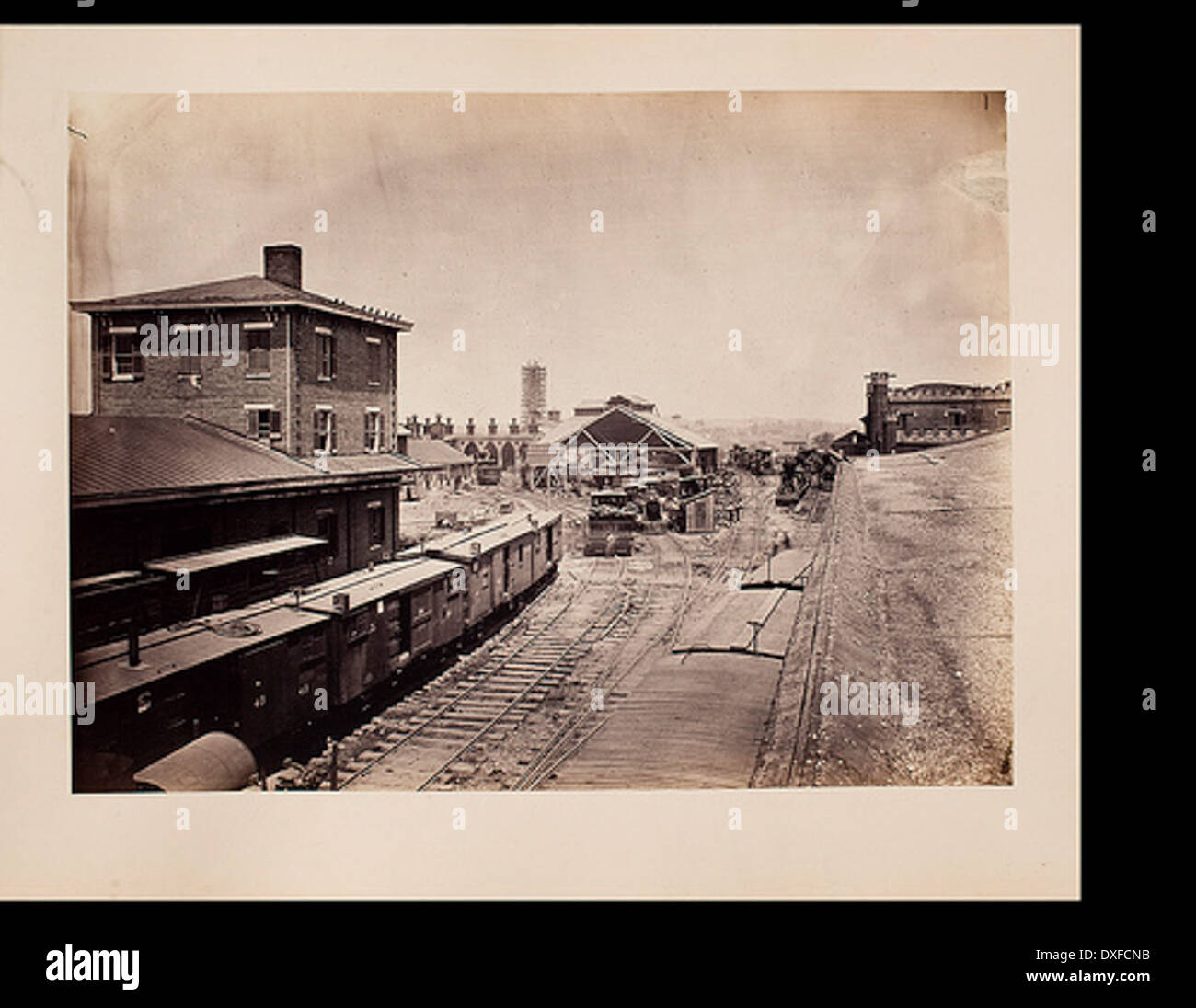 A historical photograph of a railroad yard, showcasing the ...