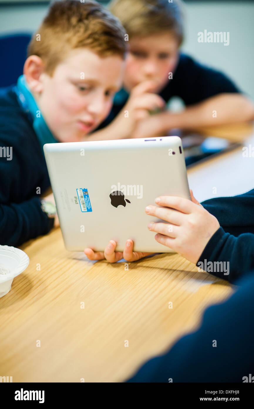 Primary school children boys using apple iPad tablet computers in class ...