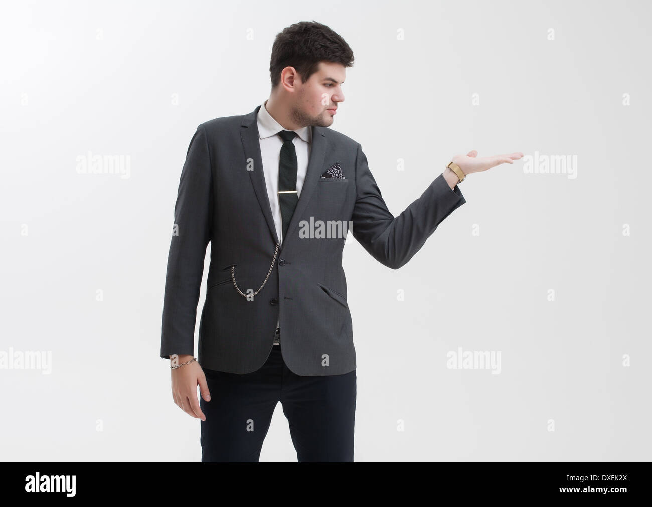 Handsome man makes a gesture with his hand. Beautiful gray suit ...