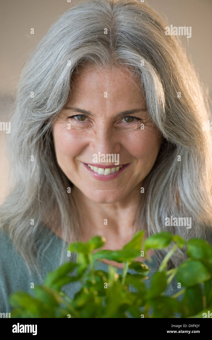 Mature woman holding basel plant Stock Photo - Alamy
