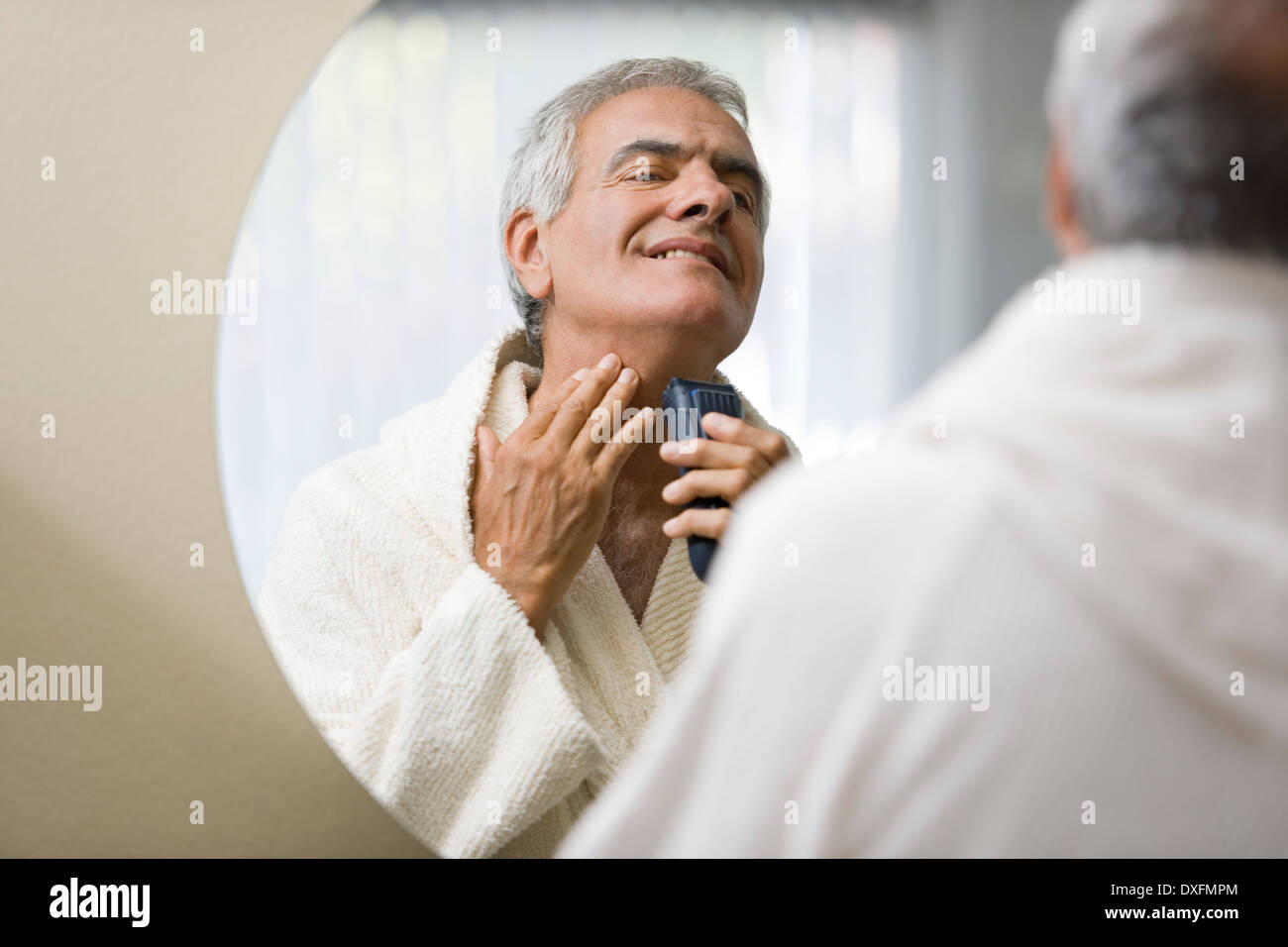 Mature man shaving in bathroom mirror Stock Photo - Alamy