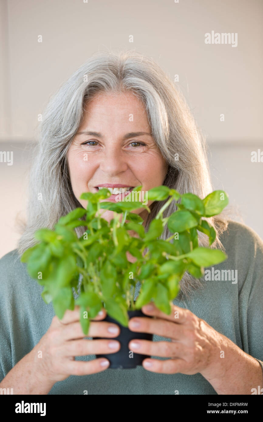 Mature woman holding basel plant Stock Photo - Alamy