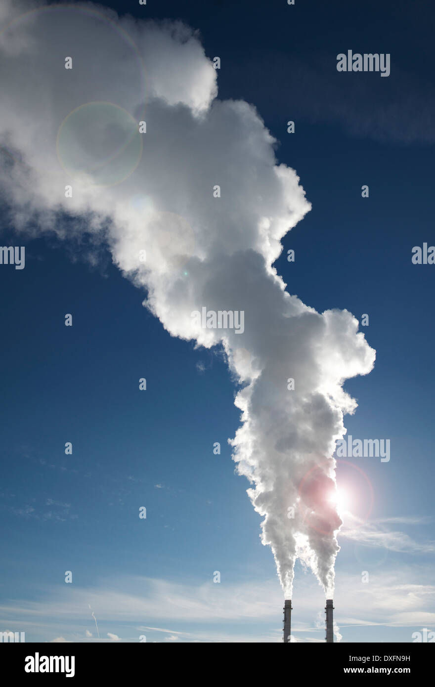 Industrial smoke stacks with steam billowing into blue sky, Toronto ...