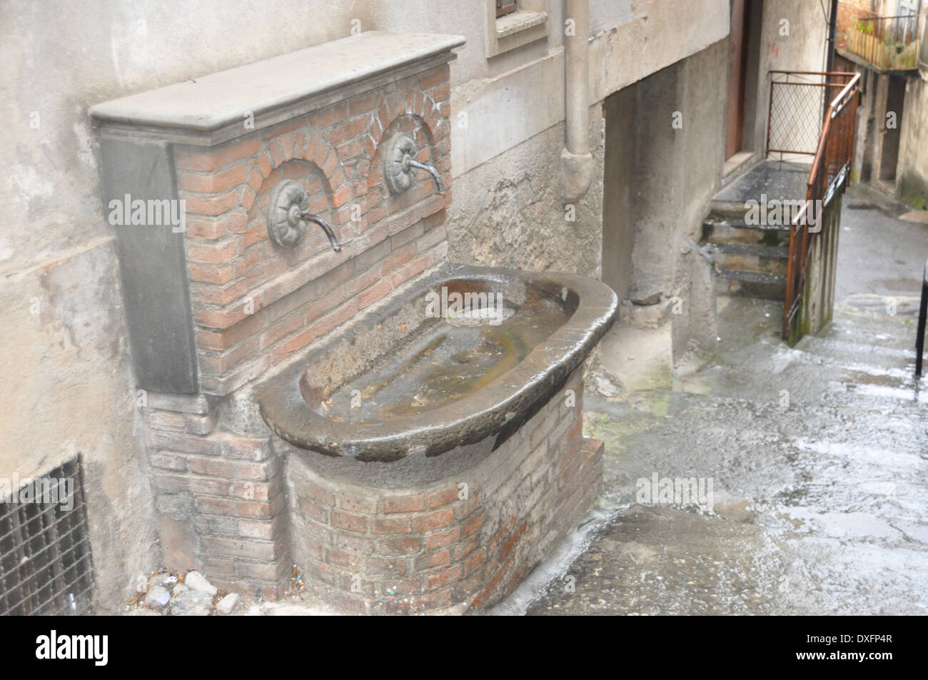 Drinking water fountain in a narrow street in the Southern Italian ...