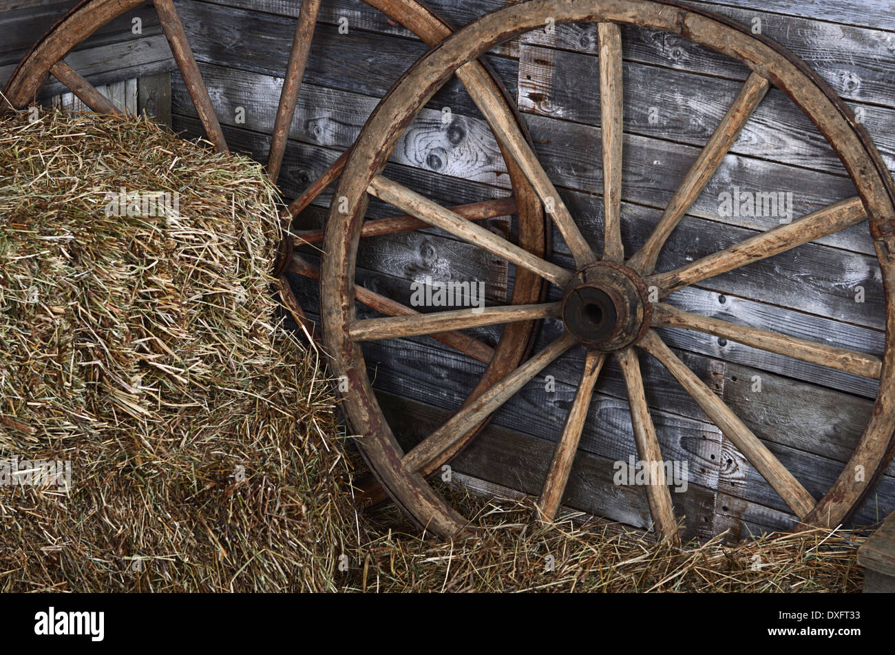 The old wooden wheel on a hay Stock Photo - Alamy