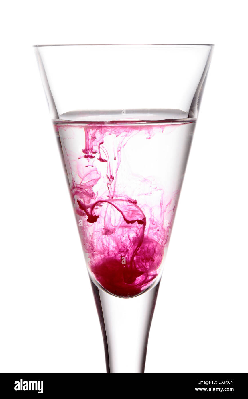 pink fluid falling on a glass of water on a white background Stock ...