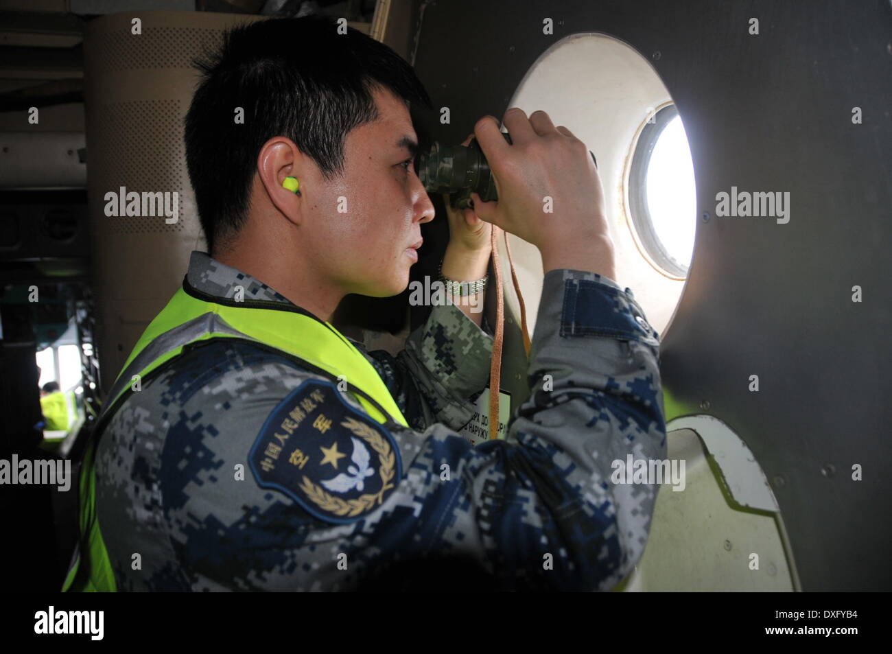 Perth. 26th Mar, 2014. A crew member of Chinese IL-76 aircraft scans ...