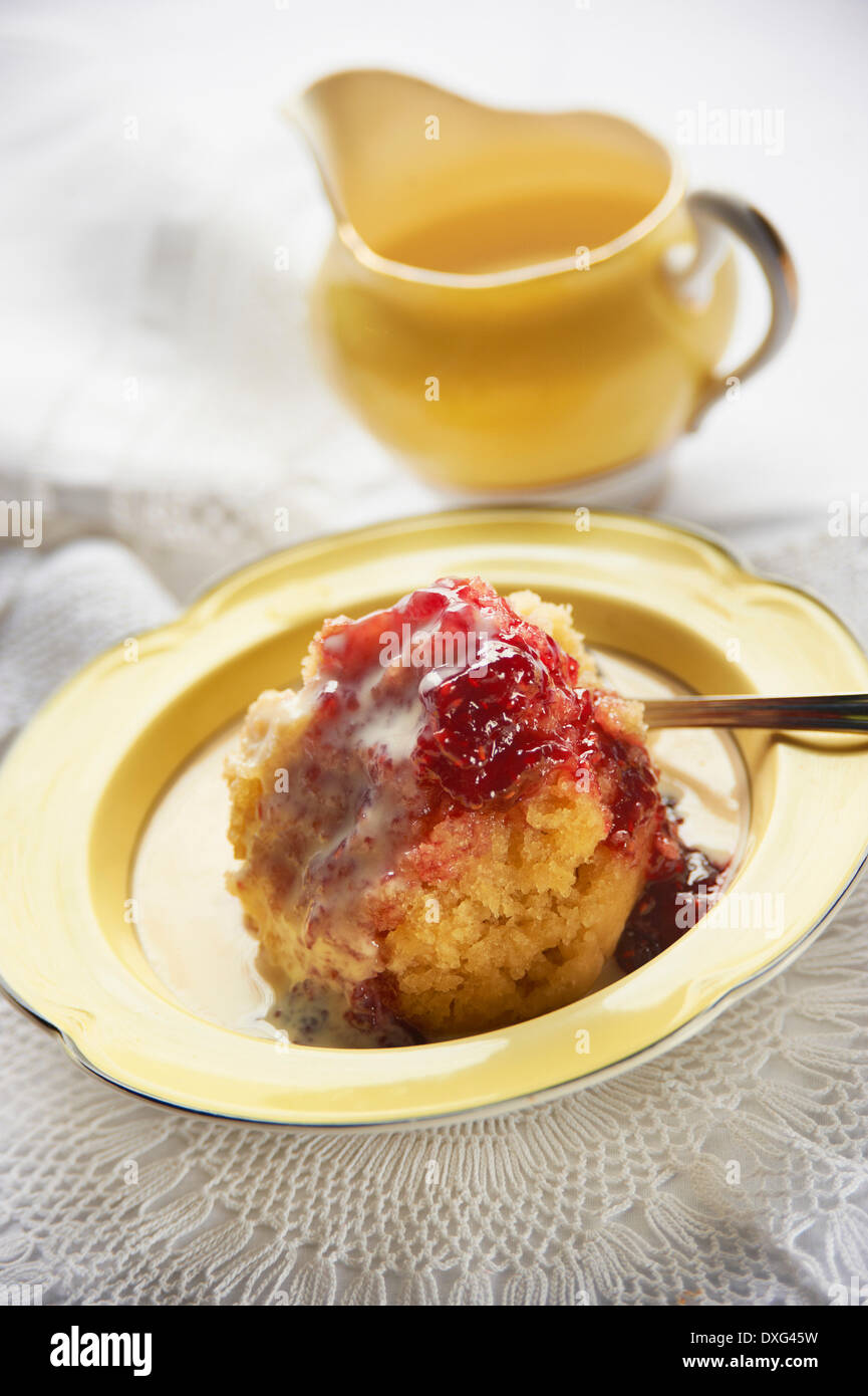 Bowl Of Steamed Jam Pudding With Jug Of Custard Stock Photo - Alamy