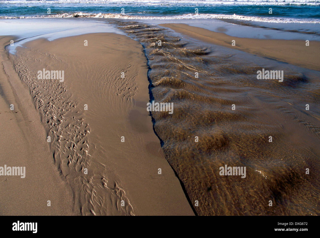 Ripples in flowing river mouth at beach Stock Photo - Alamy