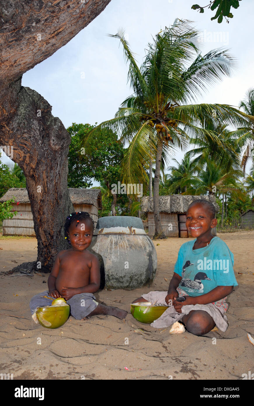 Little Mozambican girls, eating coconut outside homeastead Stock Photo ...
