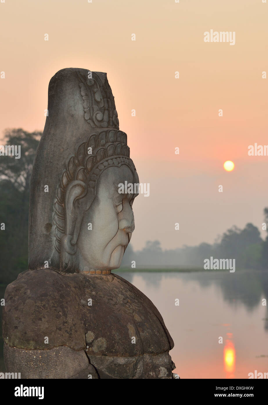 Sunrise over water and in between row of gods on path to Angkor Thorn ...
