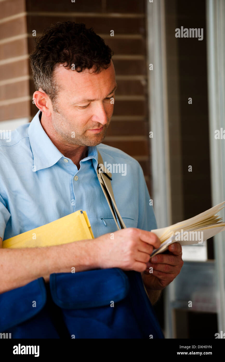 Mailman delivering mail Stock Photo - Alamy