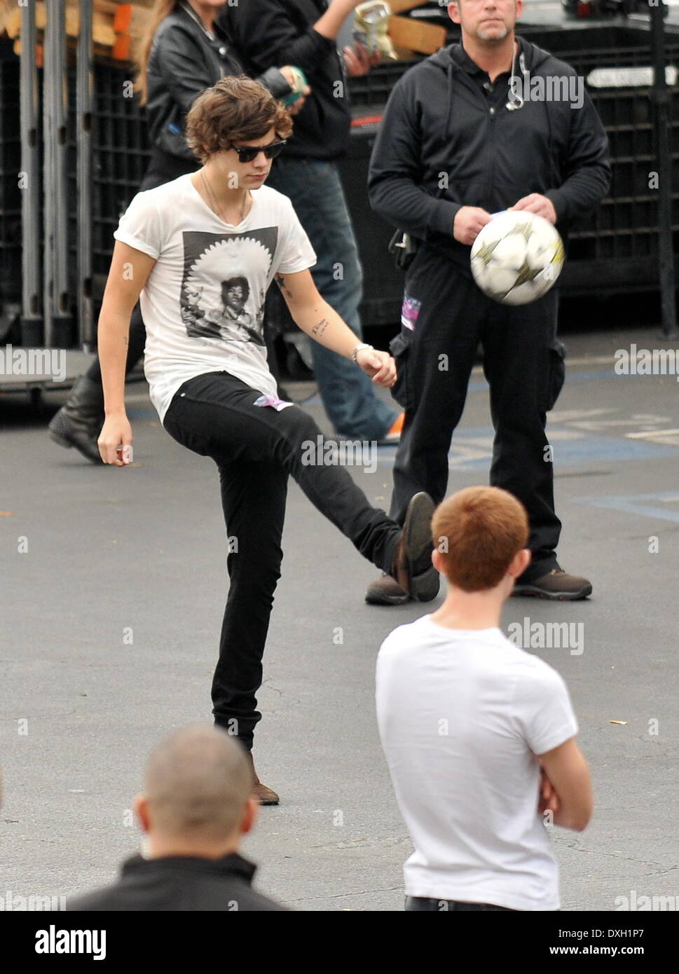 Harry Styles One Direction band members playing soccer in the parking ...