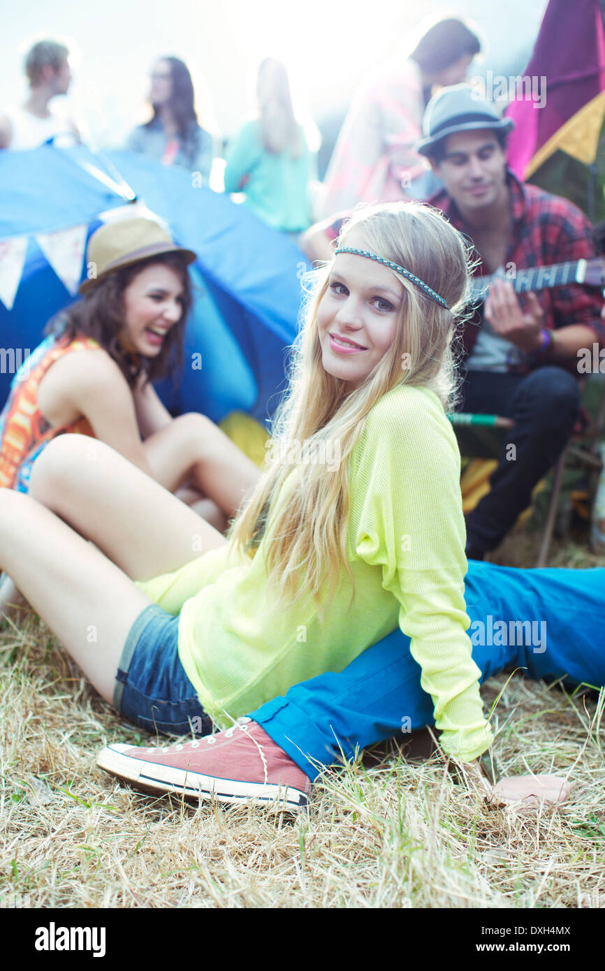Portrait of woman hanging out with friends outside tents at music ...
