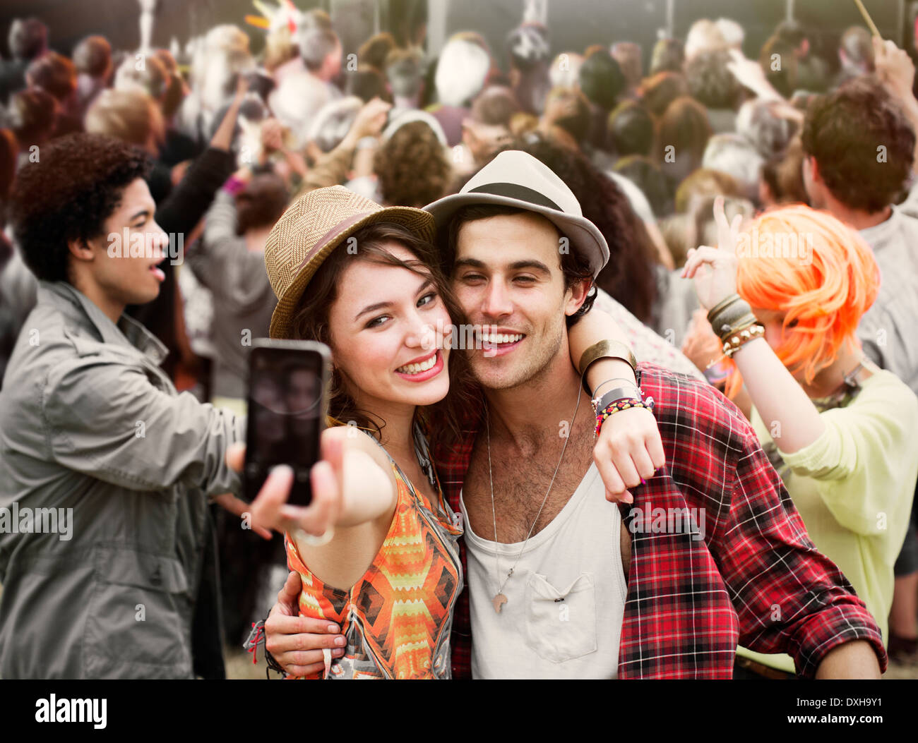 Couple taking self-portrait at music festival Stock Photo - Alamy