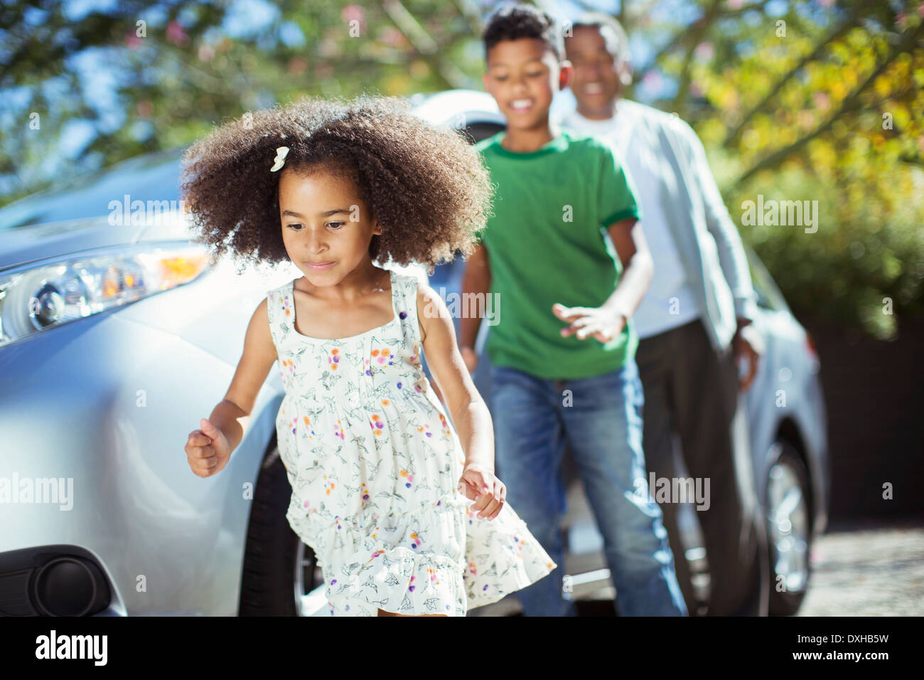 Family running outside car Stock Photo - Alamy
