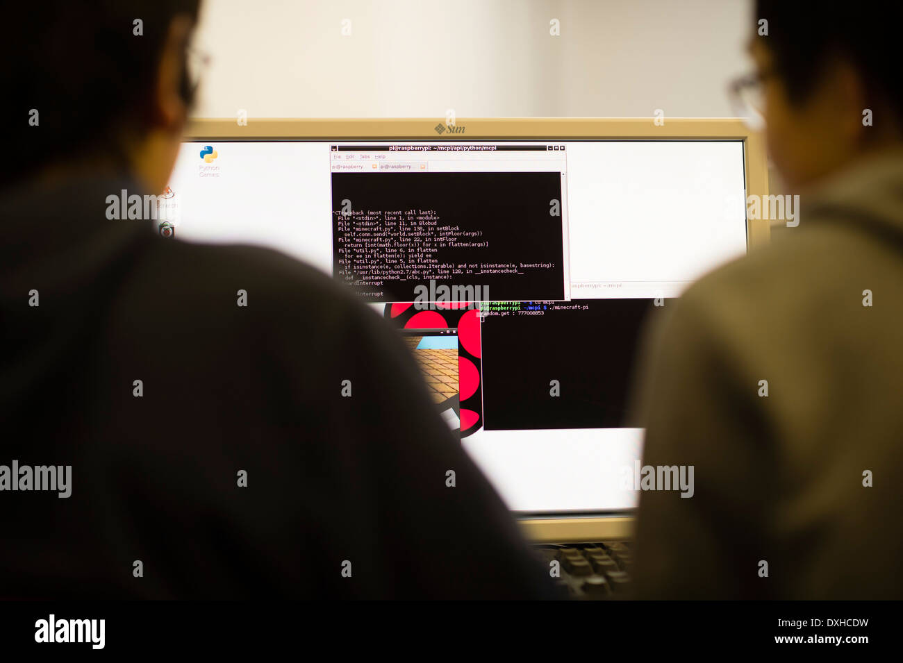 Two Teenagers at a computer workshop class writing code and learning to ...