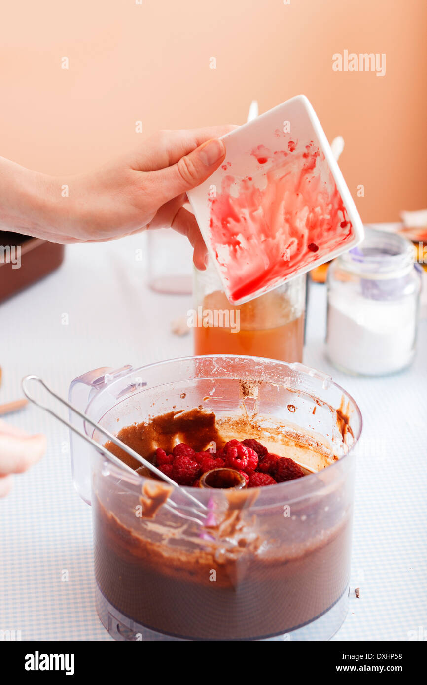 Making Cake - Mixing chocolate batter with raspberries Stock Photo - Alamy