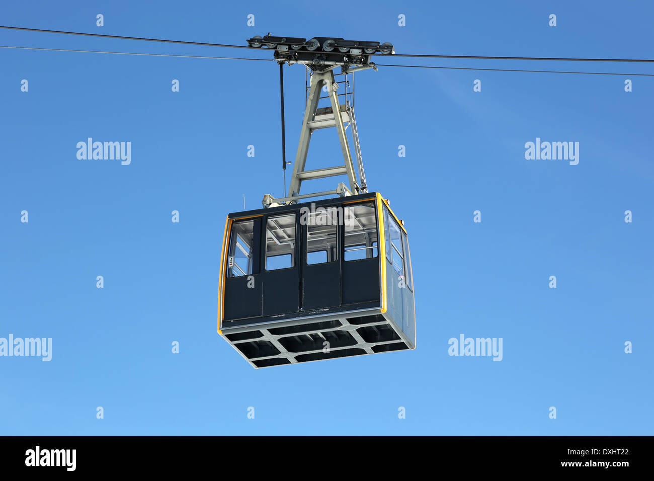 Cabin of a cable car hanging on cables over blue sky Stock Photo - Alamy
