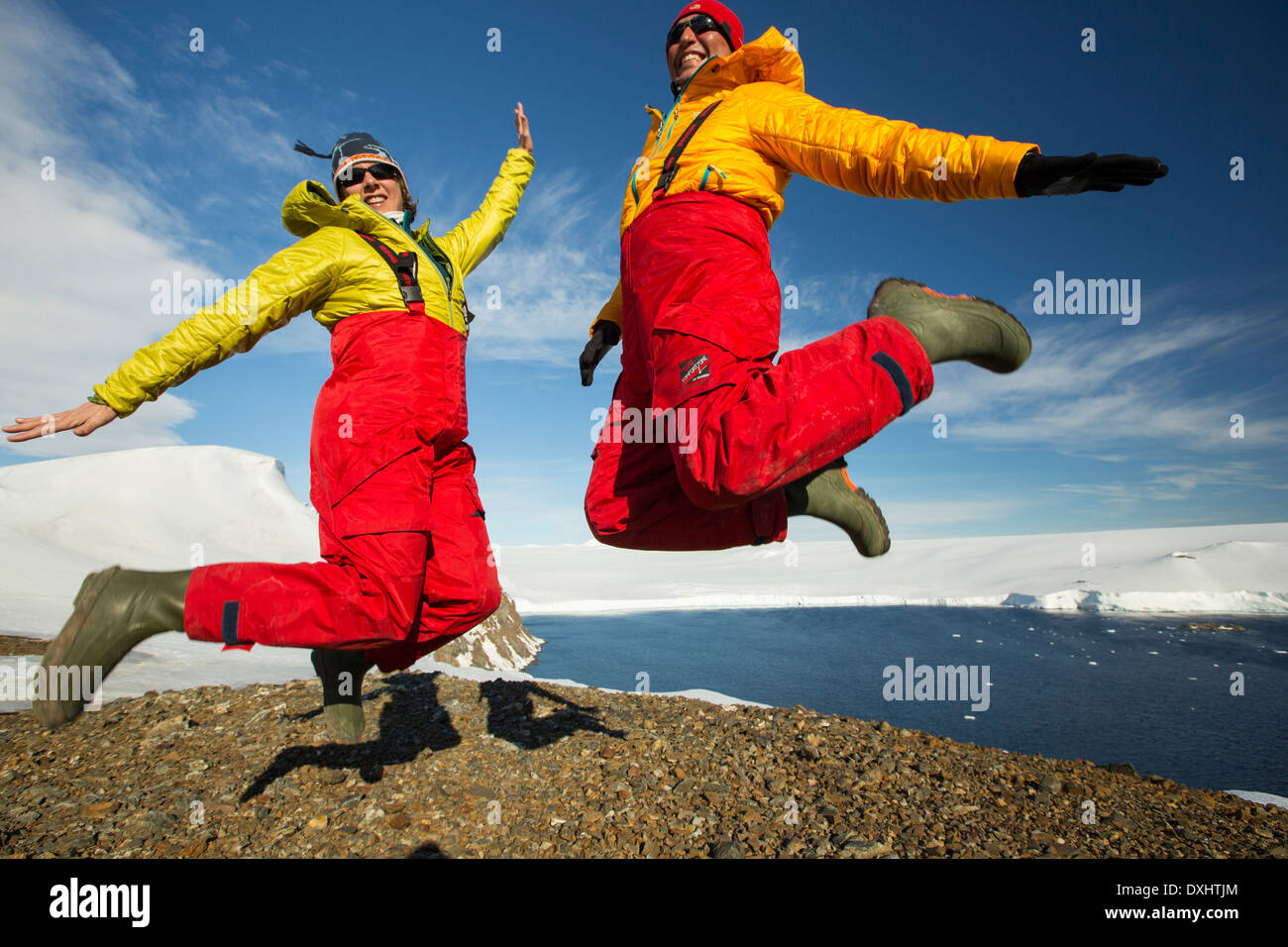 A man and woman jumping for joy from an expedition cruise on Joinville ...