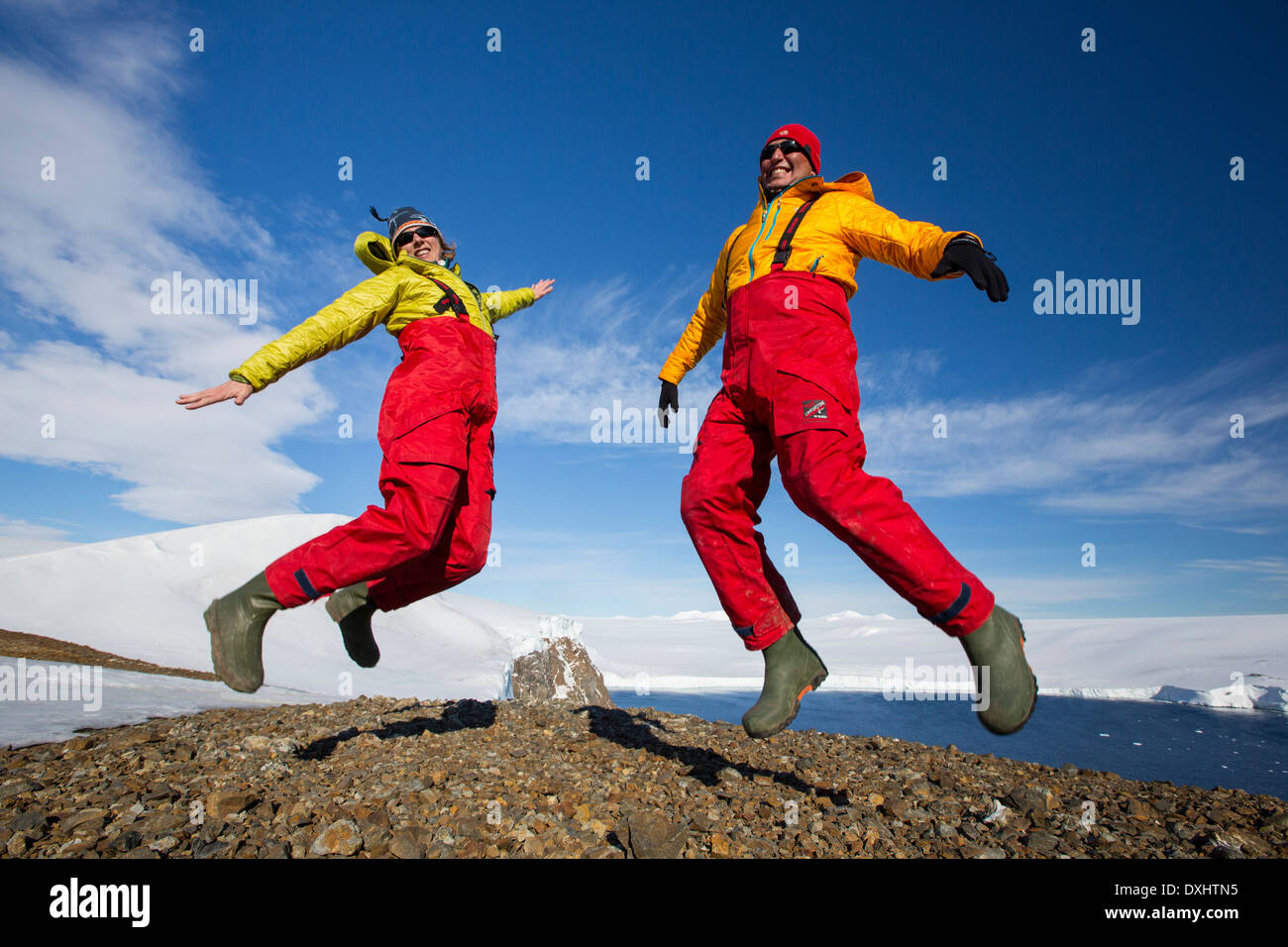 A man and woman jumping for joy from an expedition cruise on Joinville ...