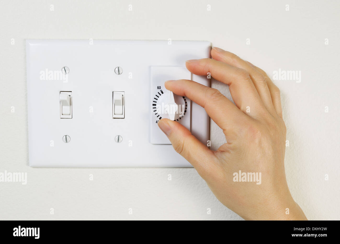 Horizontal photo of female hand adjusting bathroom fan timer Stock ...