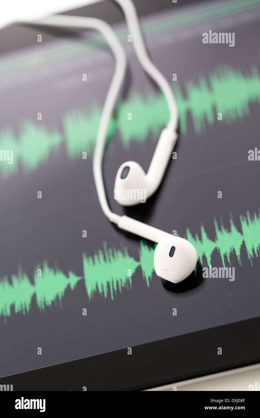 white headphones on top of computer tablet Stock Photo - Alamy