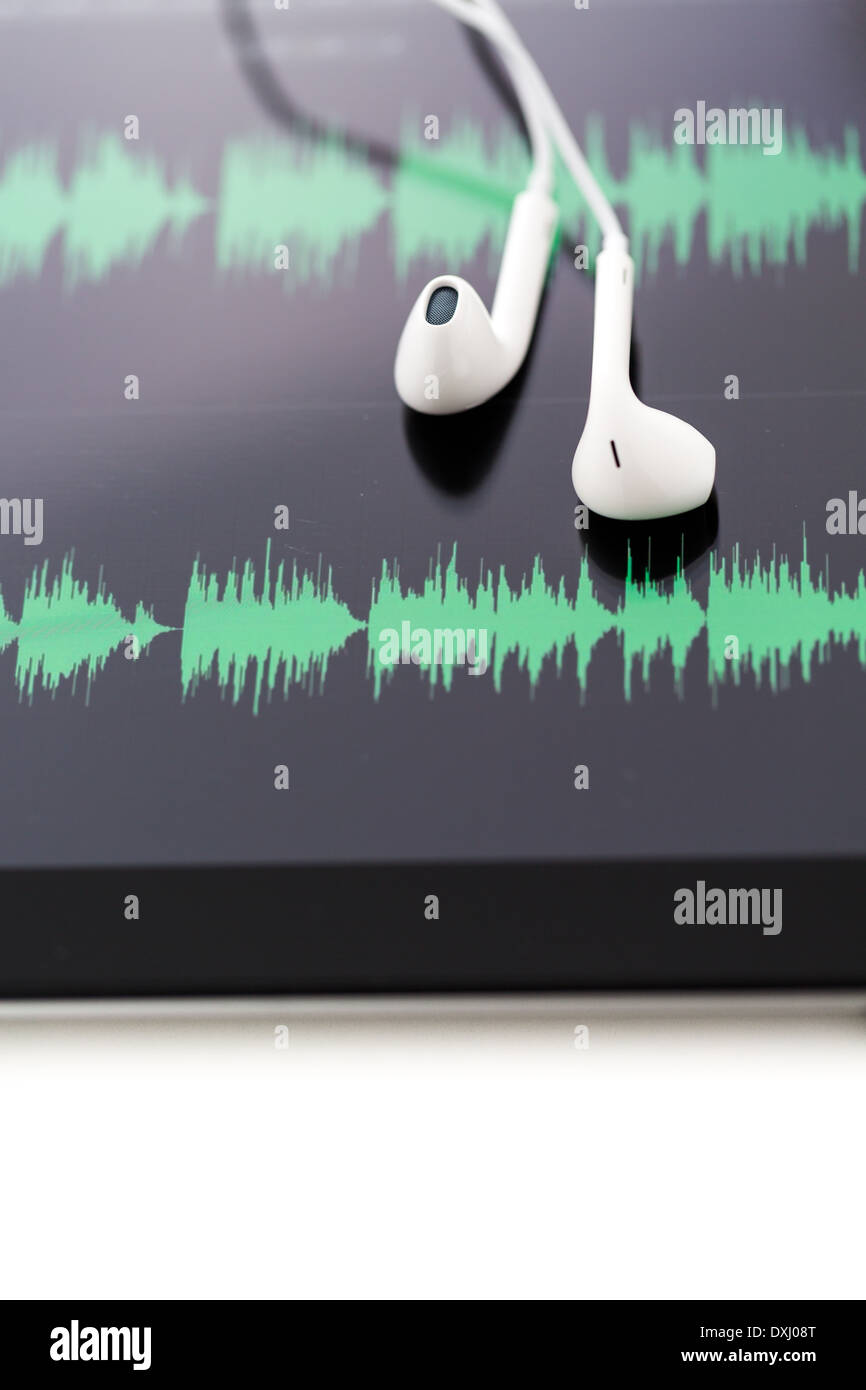 white headphones on top of computer tablet Stock Photo - Alamy