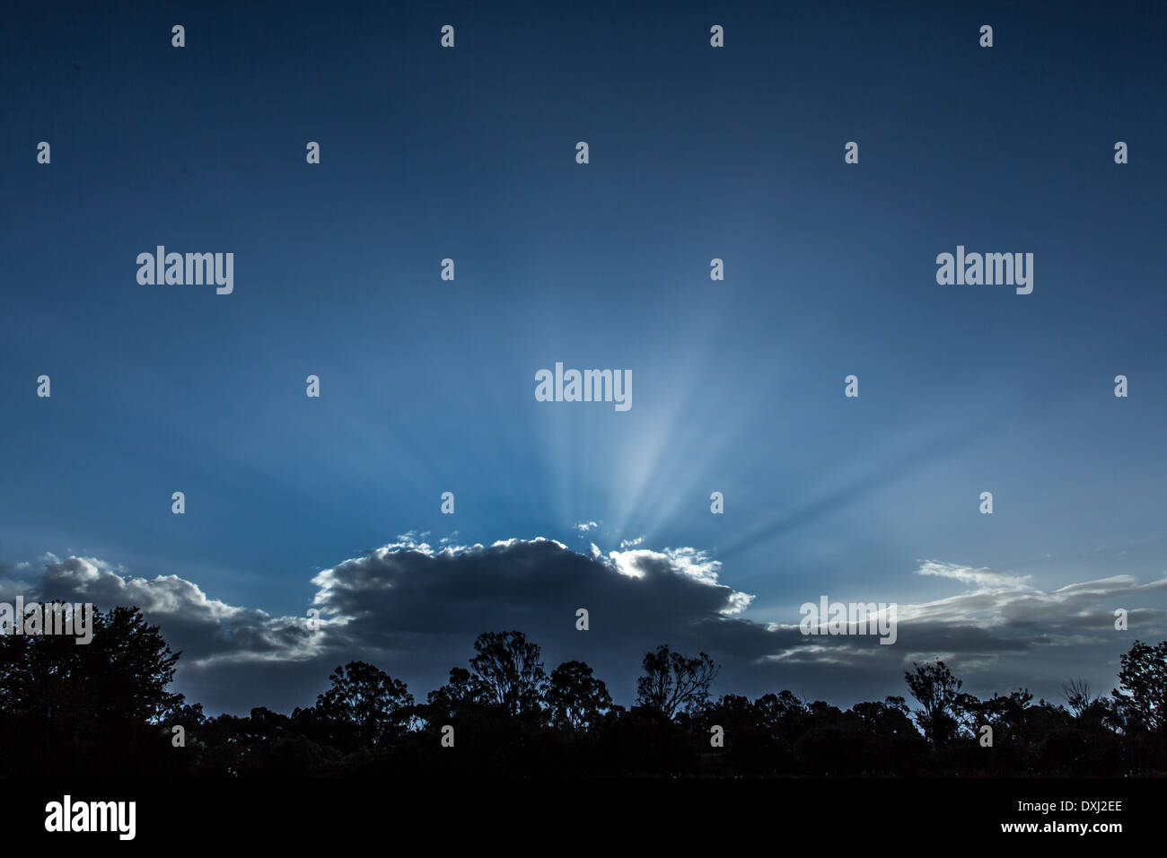 The sun hiding behind clouds but shining it's bright rays above them ...