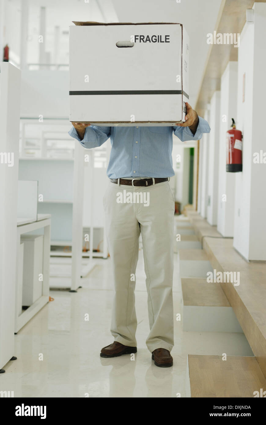 Man carrying box in office Stock Photo - Alamy