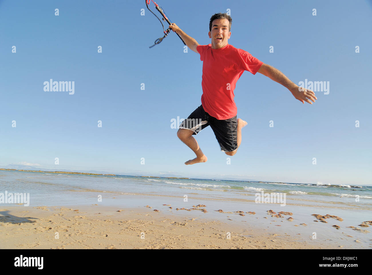 Male kite surfer jumping on beach Stock Photo - Alamy