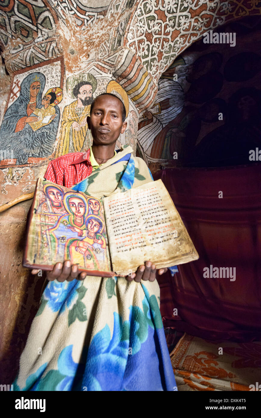 priest reading hundred years old Bible in the Abuna Yemata Guh rock ...