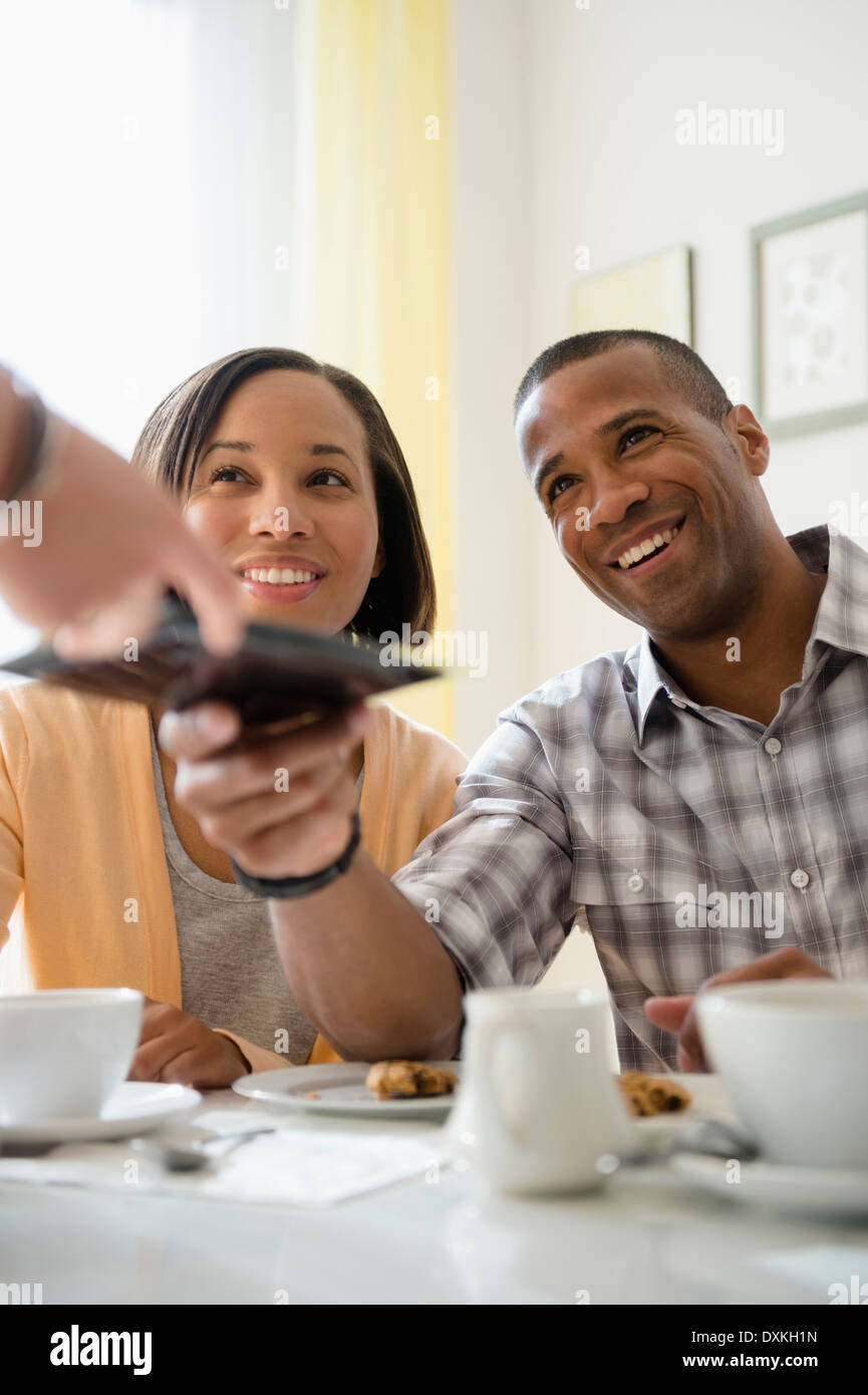 Couple receiving bill from waitress in restaurant Stock Photo - Alamy